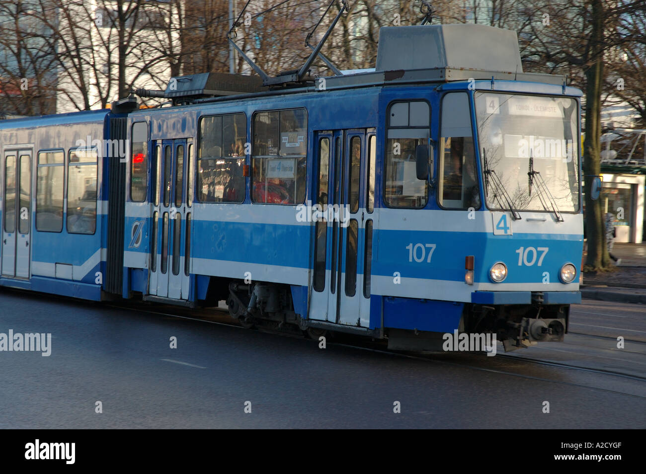 Tram travelling in the middle of the road Stock Photo - Alamy