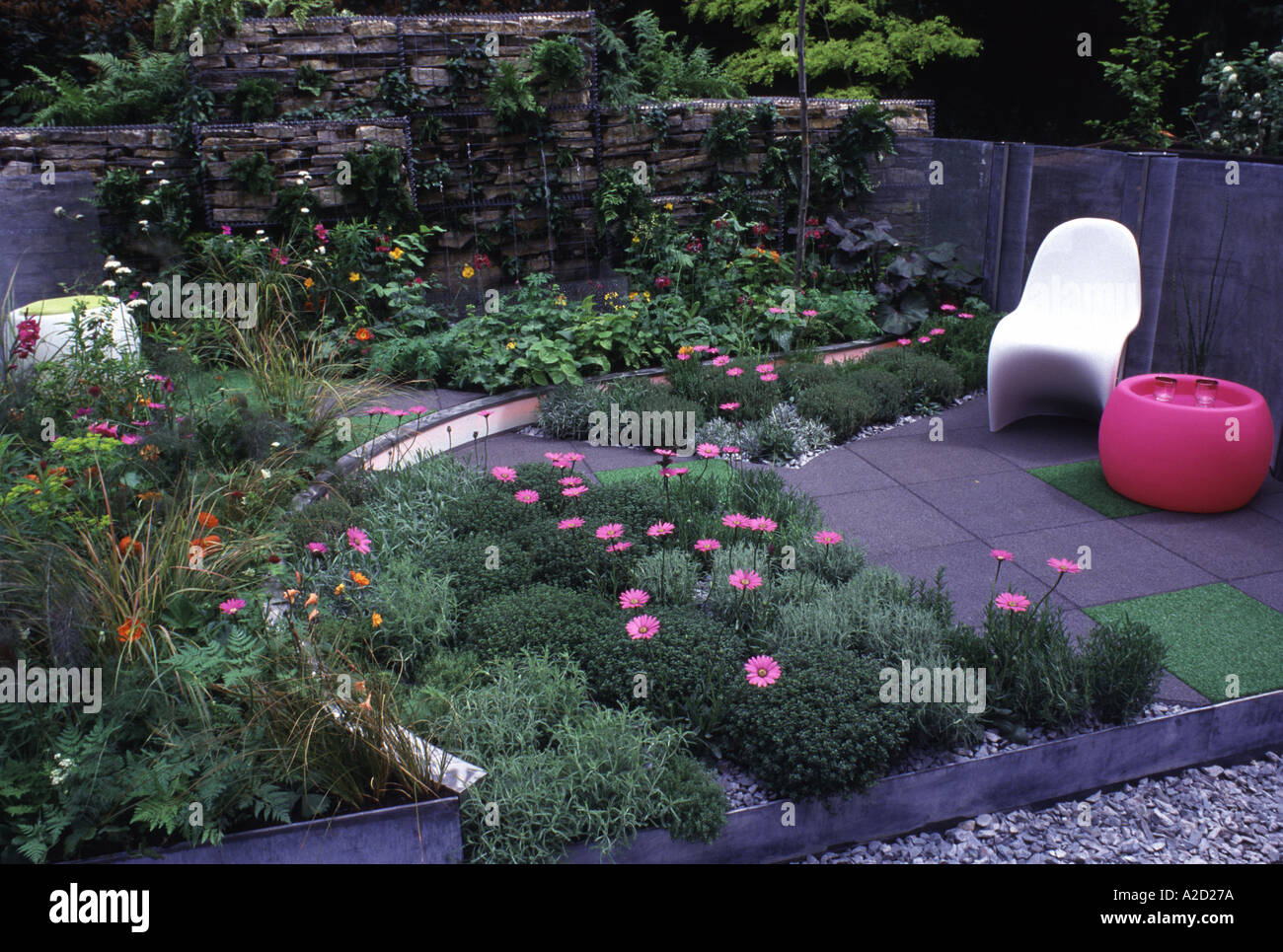 Patio area with white seating and pink table Stock Photo - Alamy