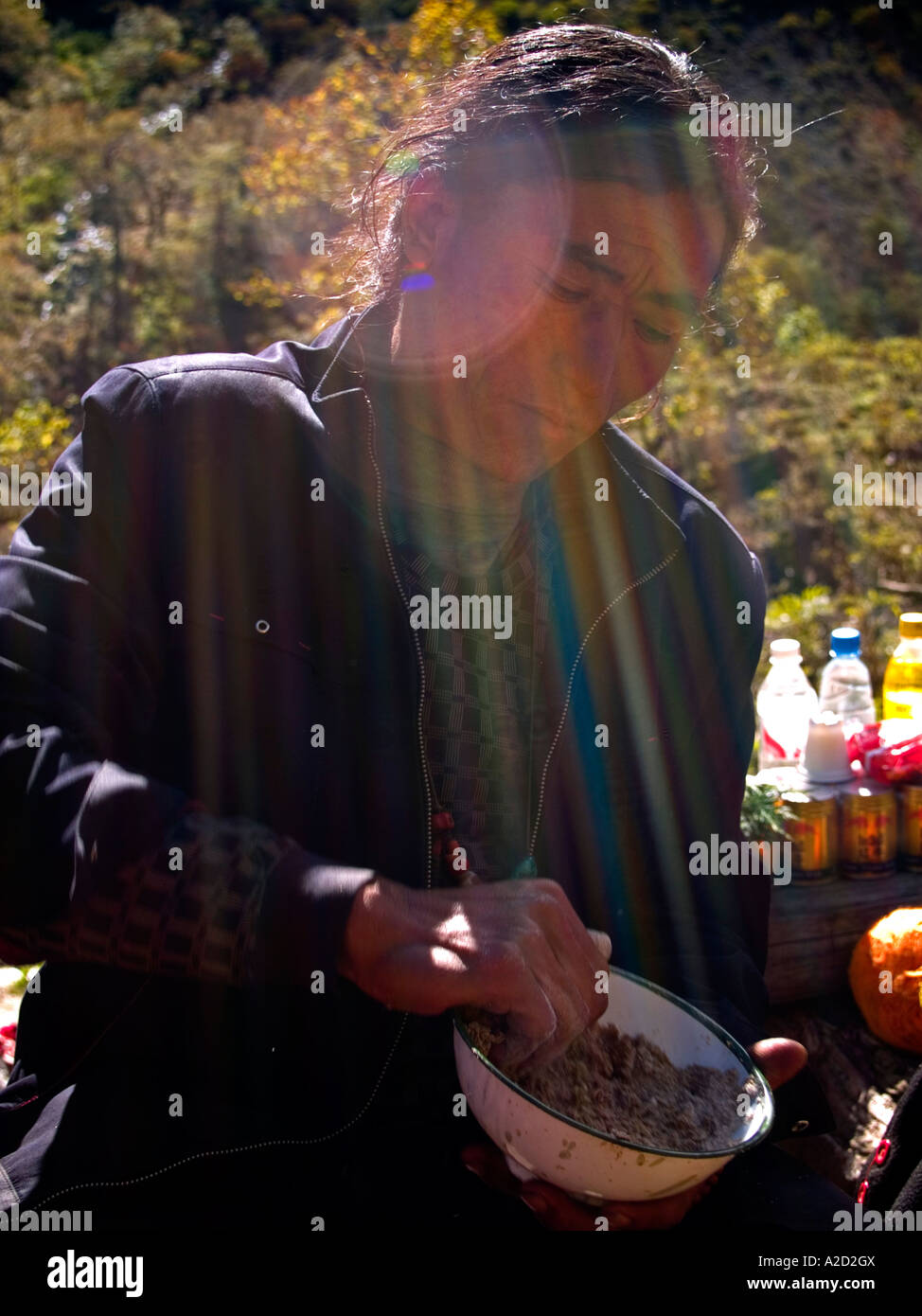 Tibetan pilgrim mixing tsampa with colored sun rays lining his body ...