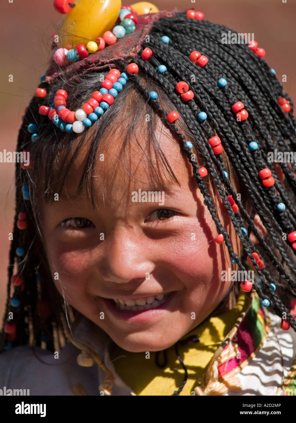 Tibetan girl with braids smiling Stock Photo - Alamy