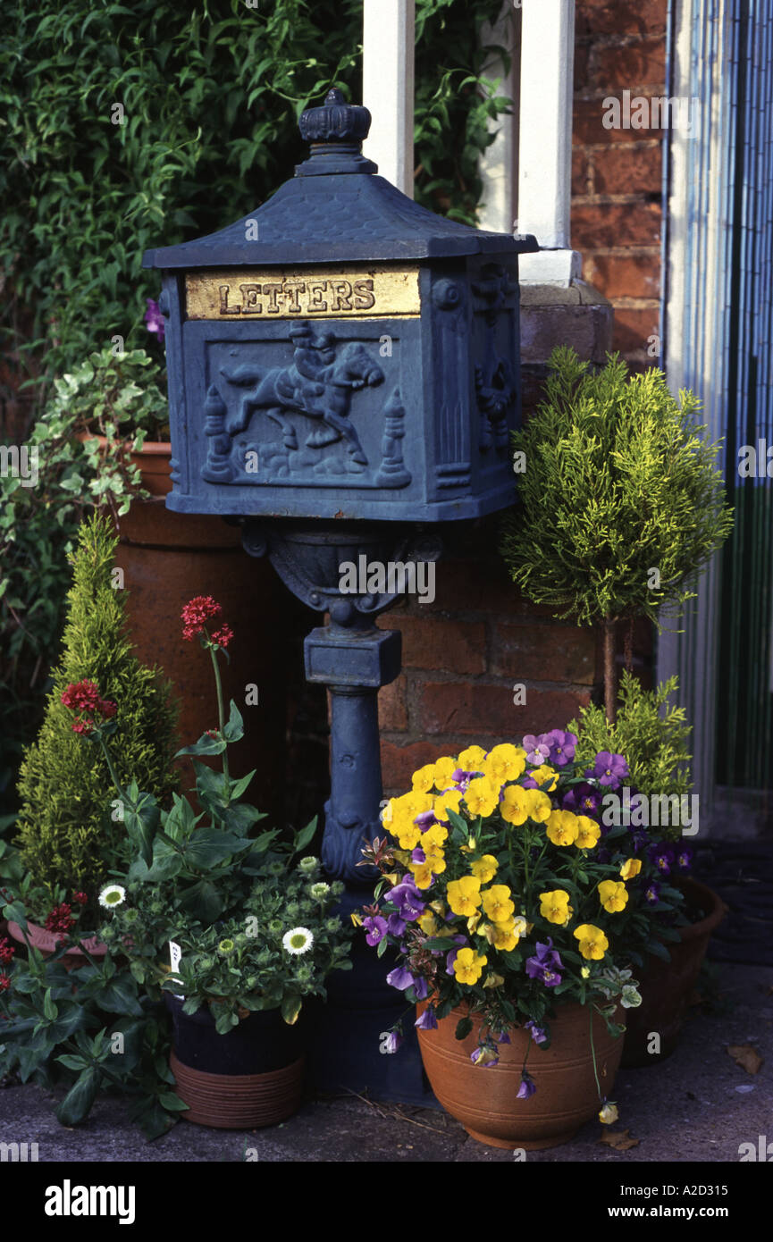 Victorian Letterbox with Shaped Conifer and potted Viola Stock Photo ...
