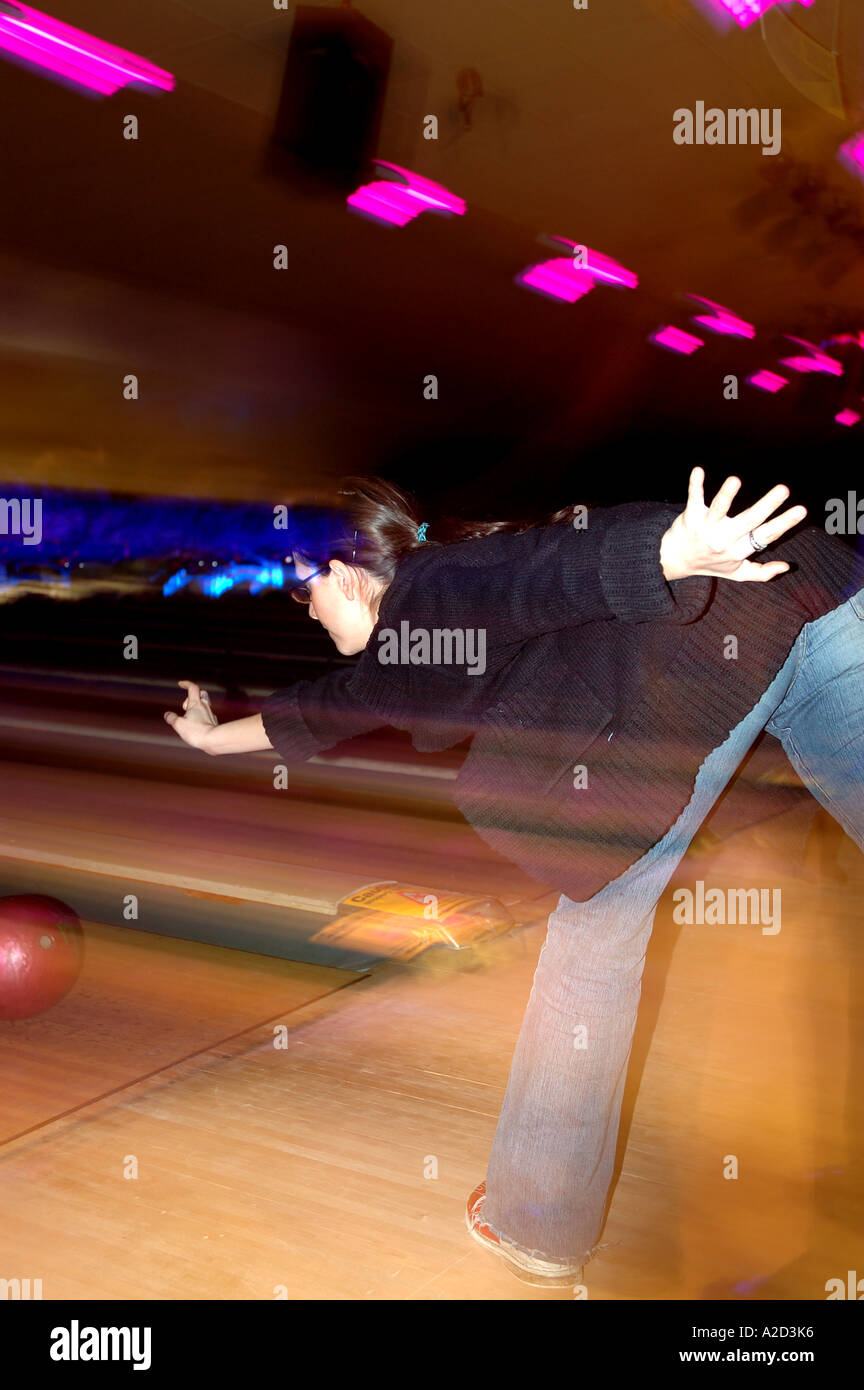 Lady bowling a red ball Stock Photo - Alamy