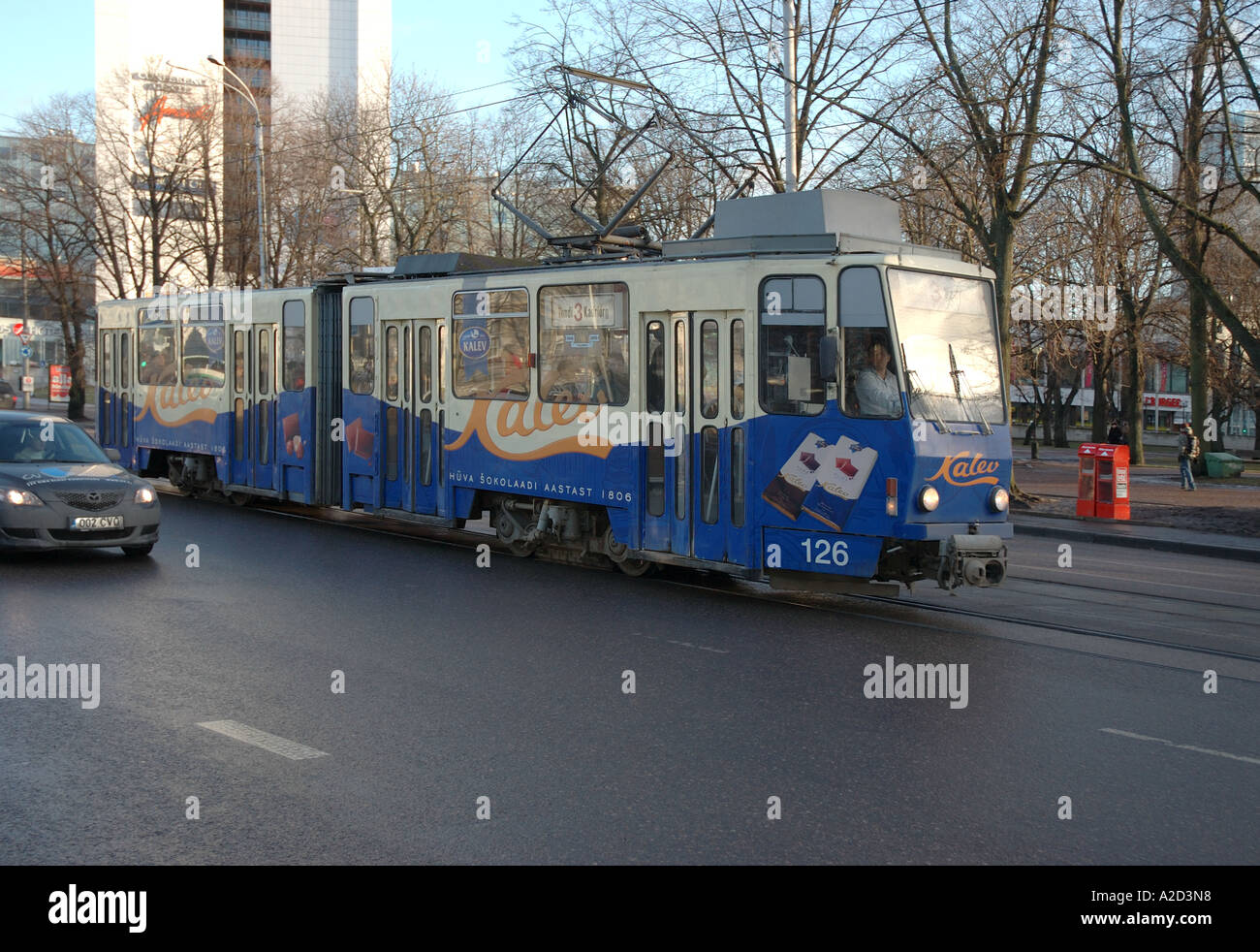 Tram travelling in the middle of the road Stock Photo - Alamy