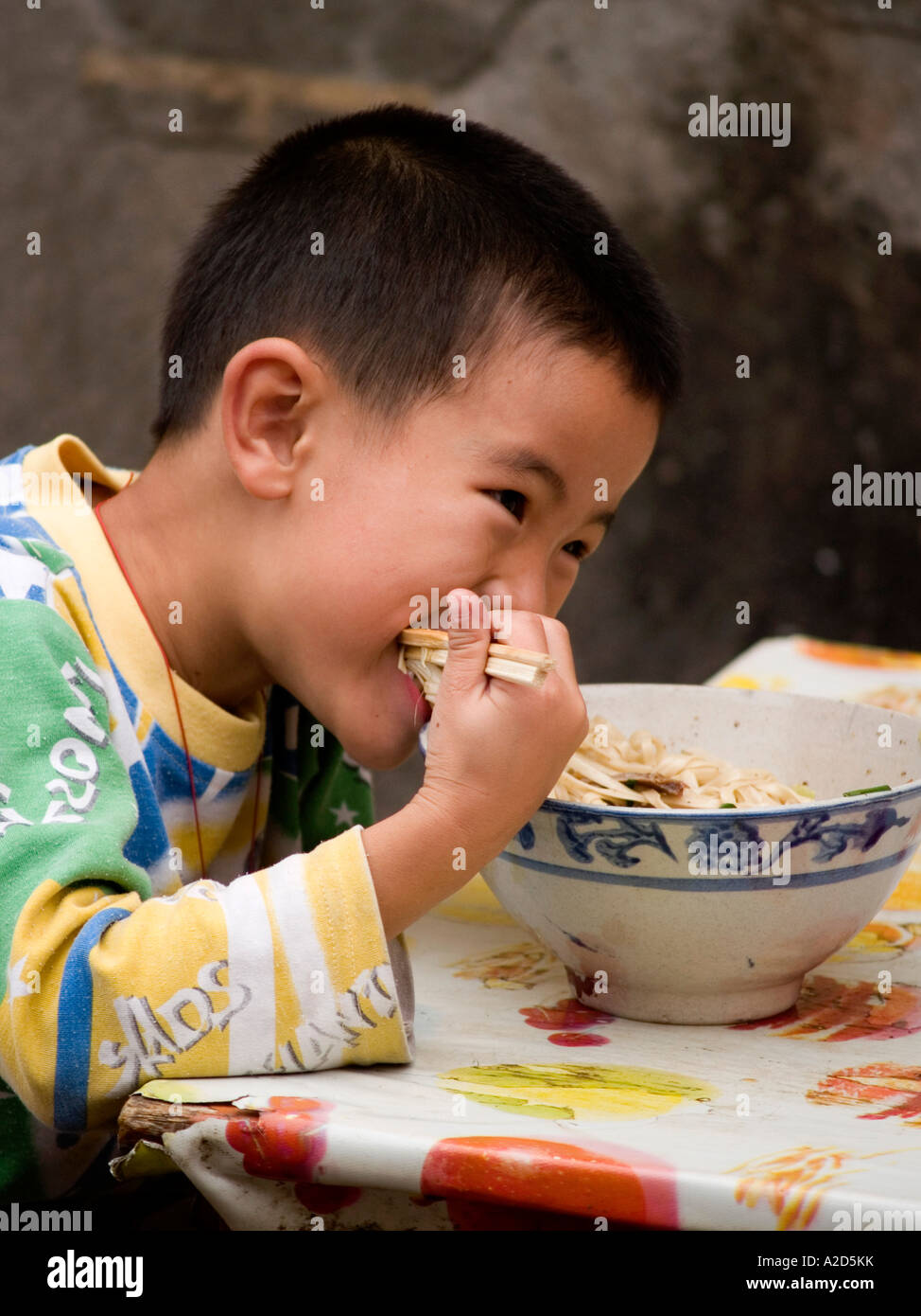 boy takes on a bowl of noodles Yuanyang China Stock Photo - Alamy
