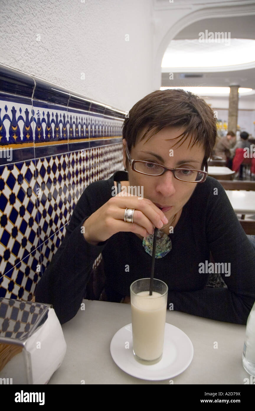 A woman drinking a traditional horchata drink in a horchateria bar in ...