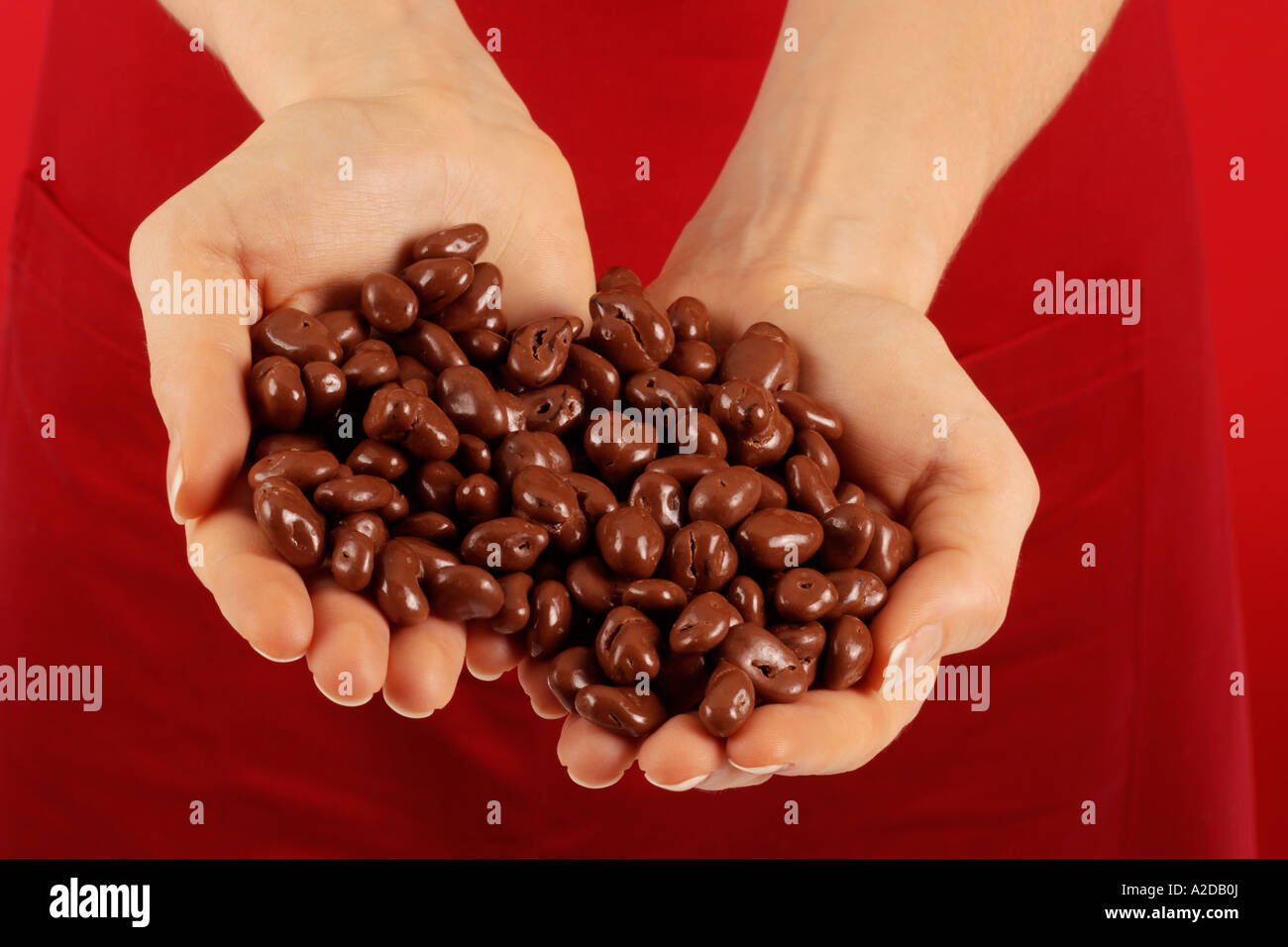 WOMAN WITH HANDFUL OF CHOCOLATE COVERED RAISINS Stock Photo - Alamy
