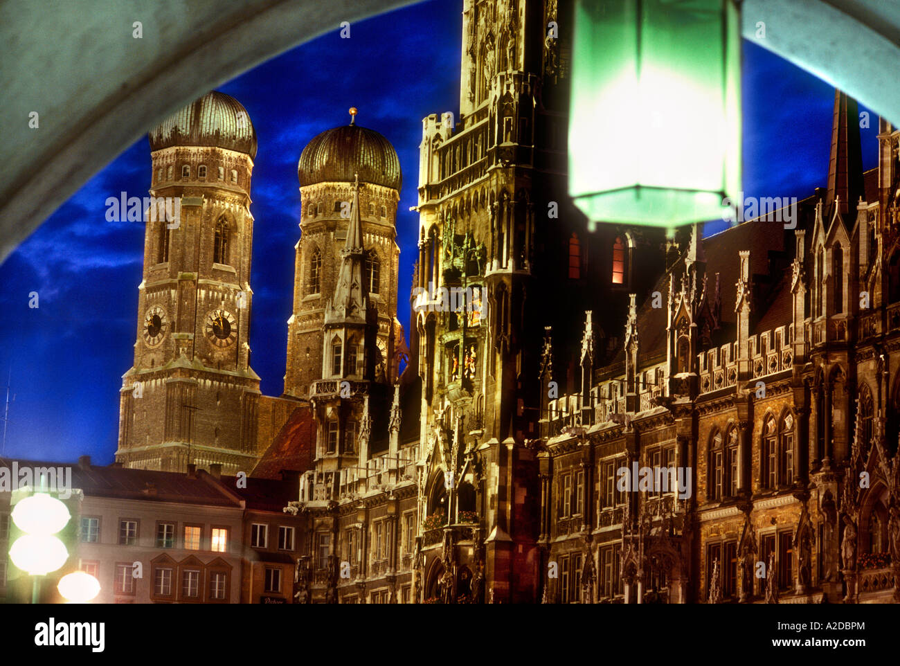 Night view of lamp & arched arcade against illuminated buildings and ...