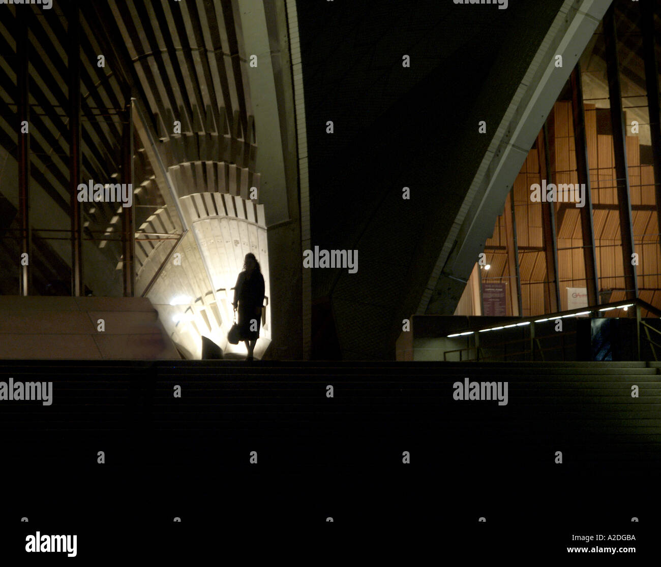FEMALE FIGURE STADING IN LIGHTED AREA OF SYDNEY OPERA HOUSE SYDNEY NEW ...
