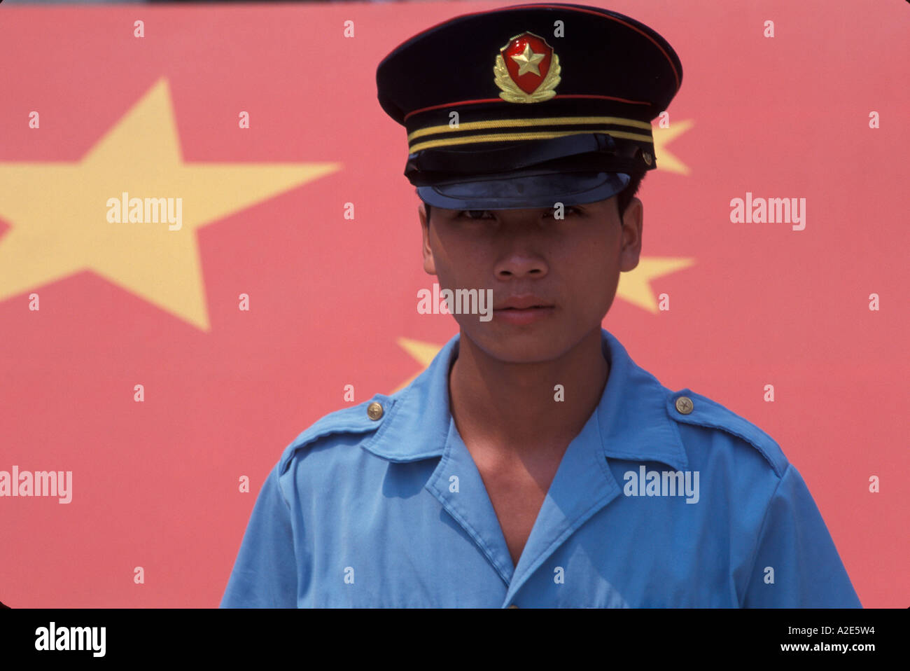 Security guard at entrance to Liuhua Park, with Chinese flag behind ...