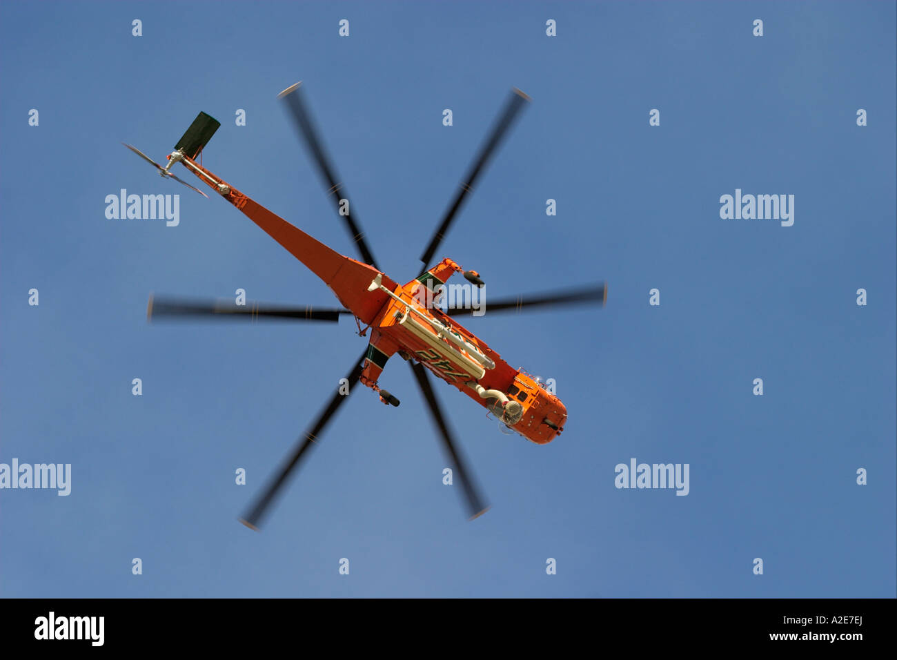 Sikorsky helicopter at a forest fire shot from below against a blue sky ...