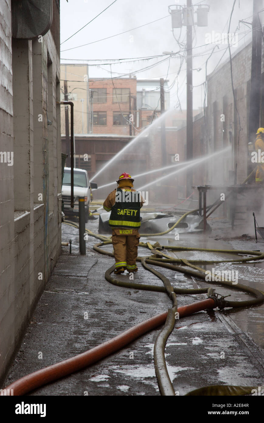 Safety officer walking down an alley at a commercial warehouse fire in ...
