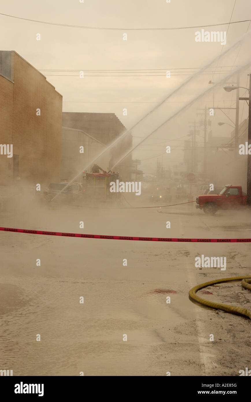 Firemen spraying water onto a fire at a brick commercial warehouse ...