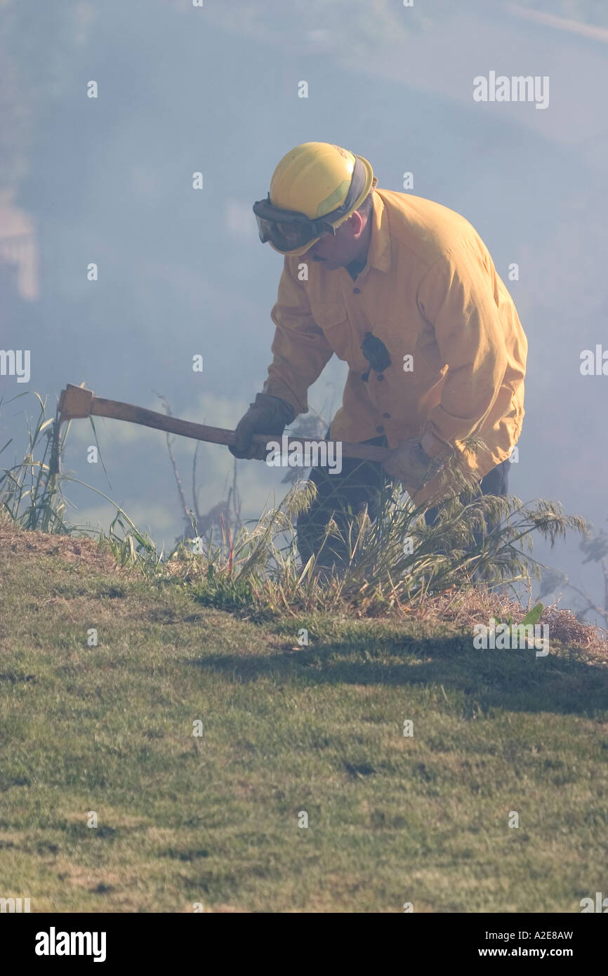 Fireman digging a trench at a brush fire Stock Photo - Alamy