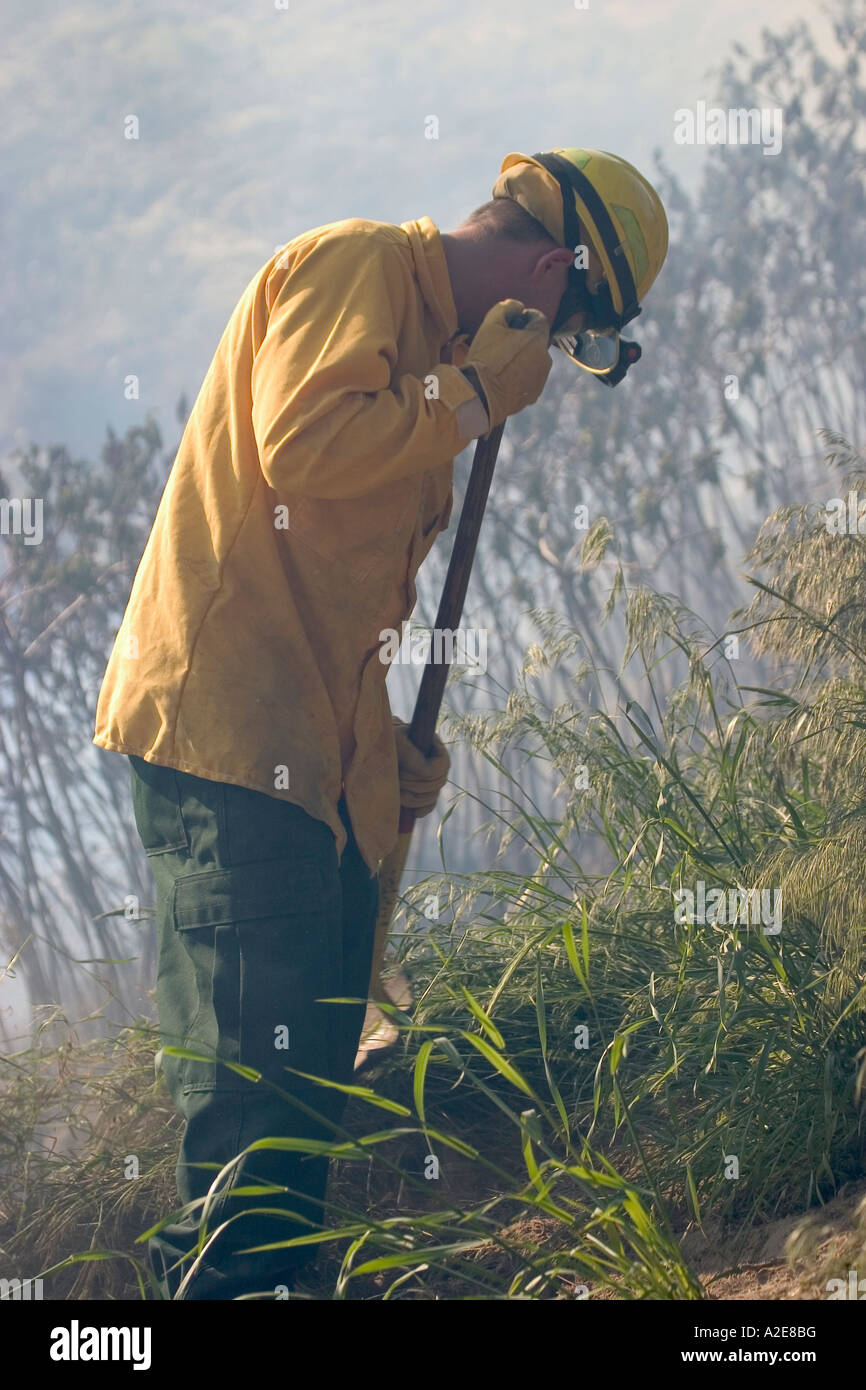 Fireman digging a trench at a brush fire Stock Photo - Alamy