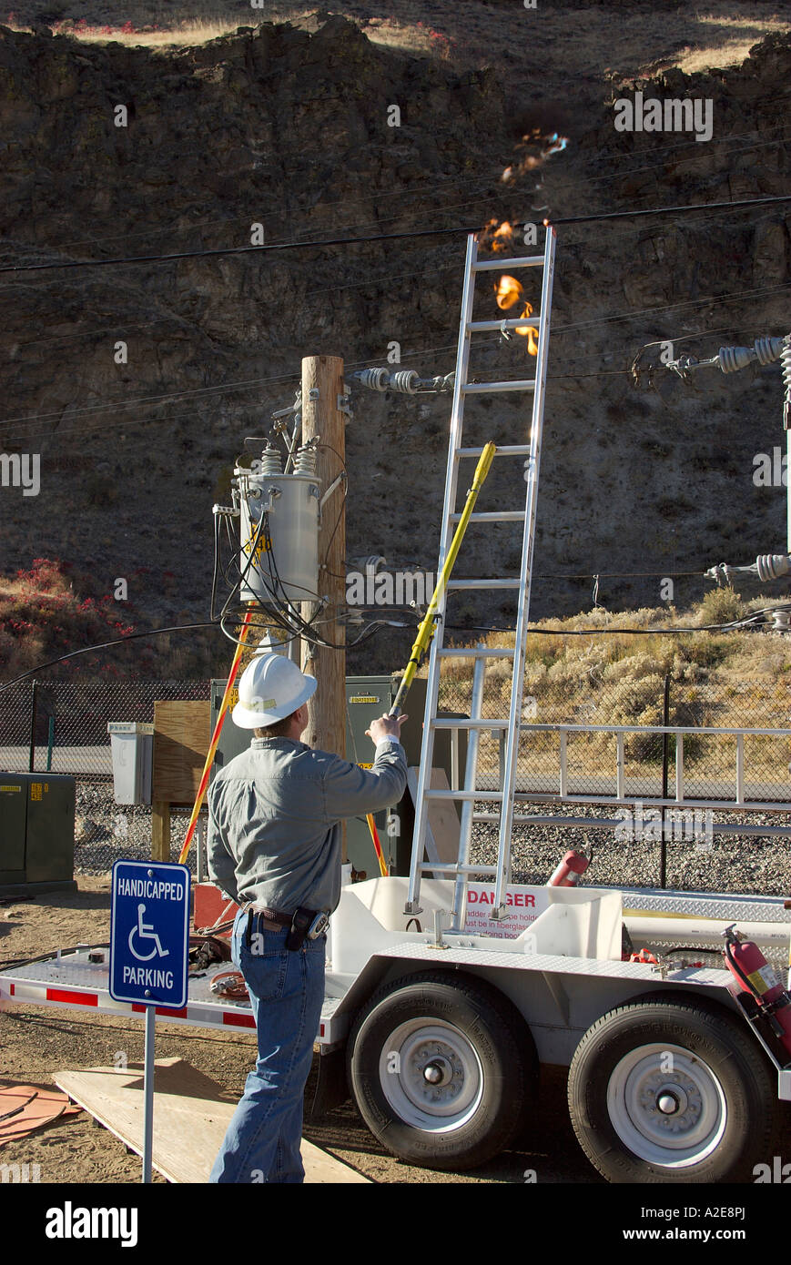 Power lineman demostrating the danger of a ladder leaning against a ...
