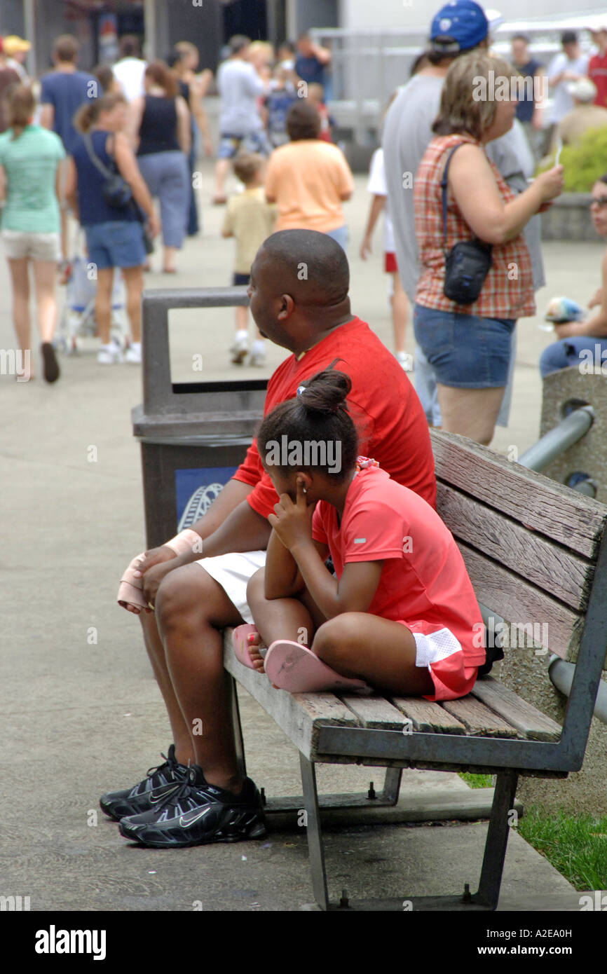 Ethnic Black father and daughter sitting on a bench at Cedar Point ...