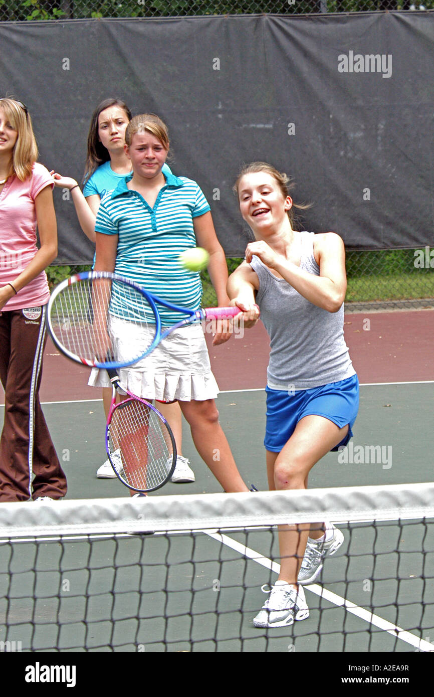 Teenage female High school students learns to play Tennis in a public ...