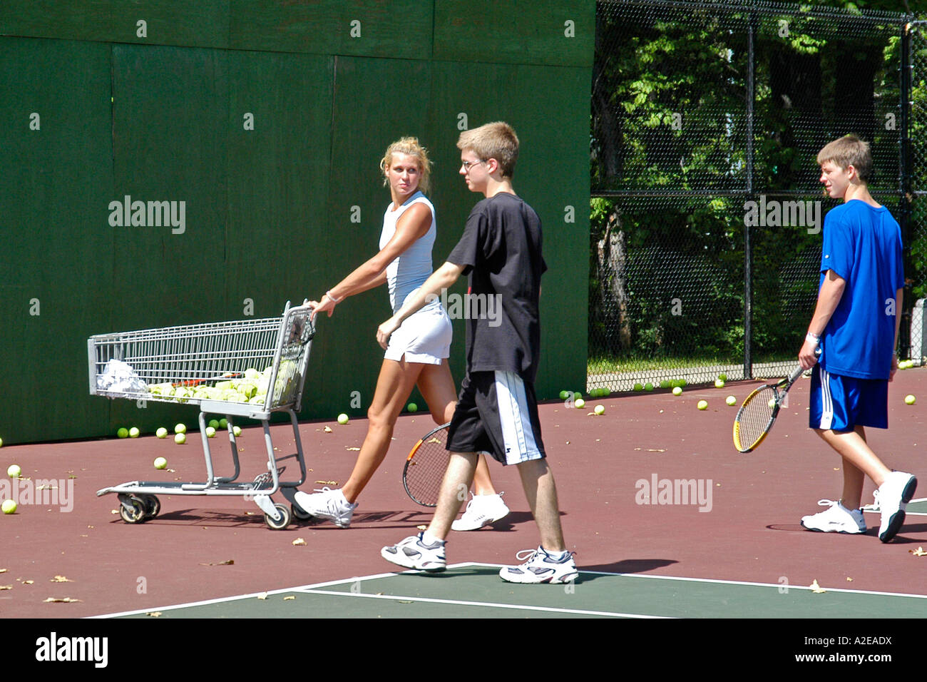 Teenage males taking Tennis lessons in a public summer-school program ...