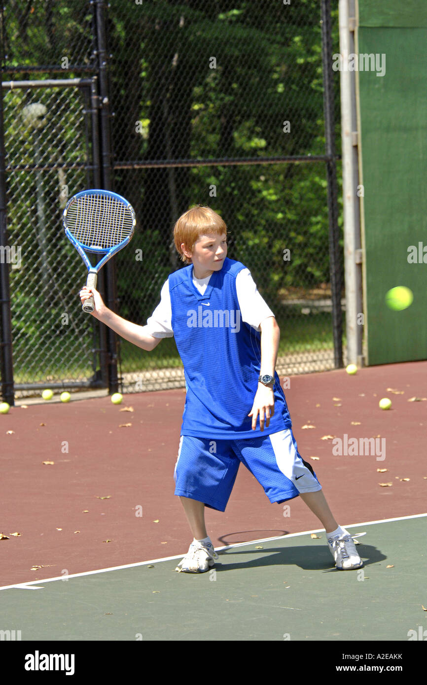 Teenage male High school student learns to play Tennis in a public ...