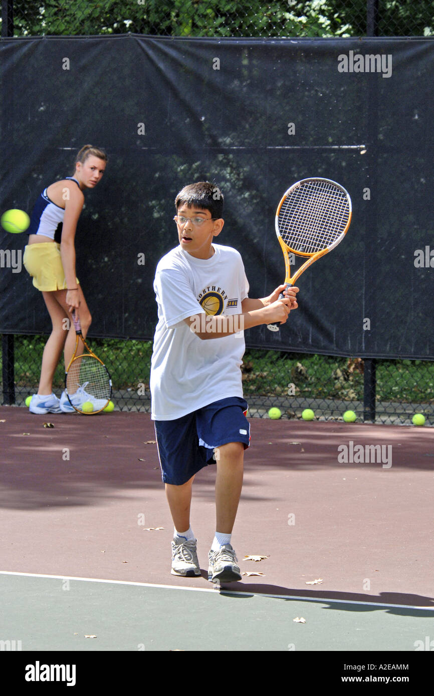 Teenage asian male taking Tennis lessons in a public summer-school ...
