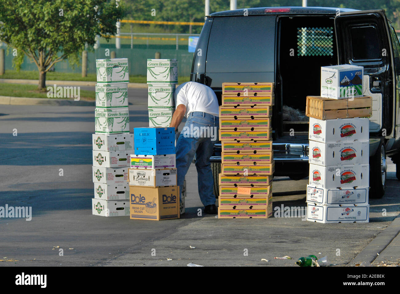 Van driver unloading a truckload rrestaurant supplies Stock Photo - Alamy
