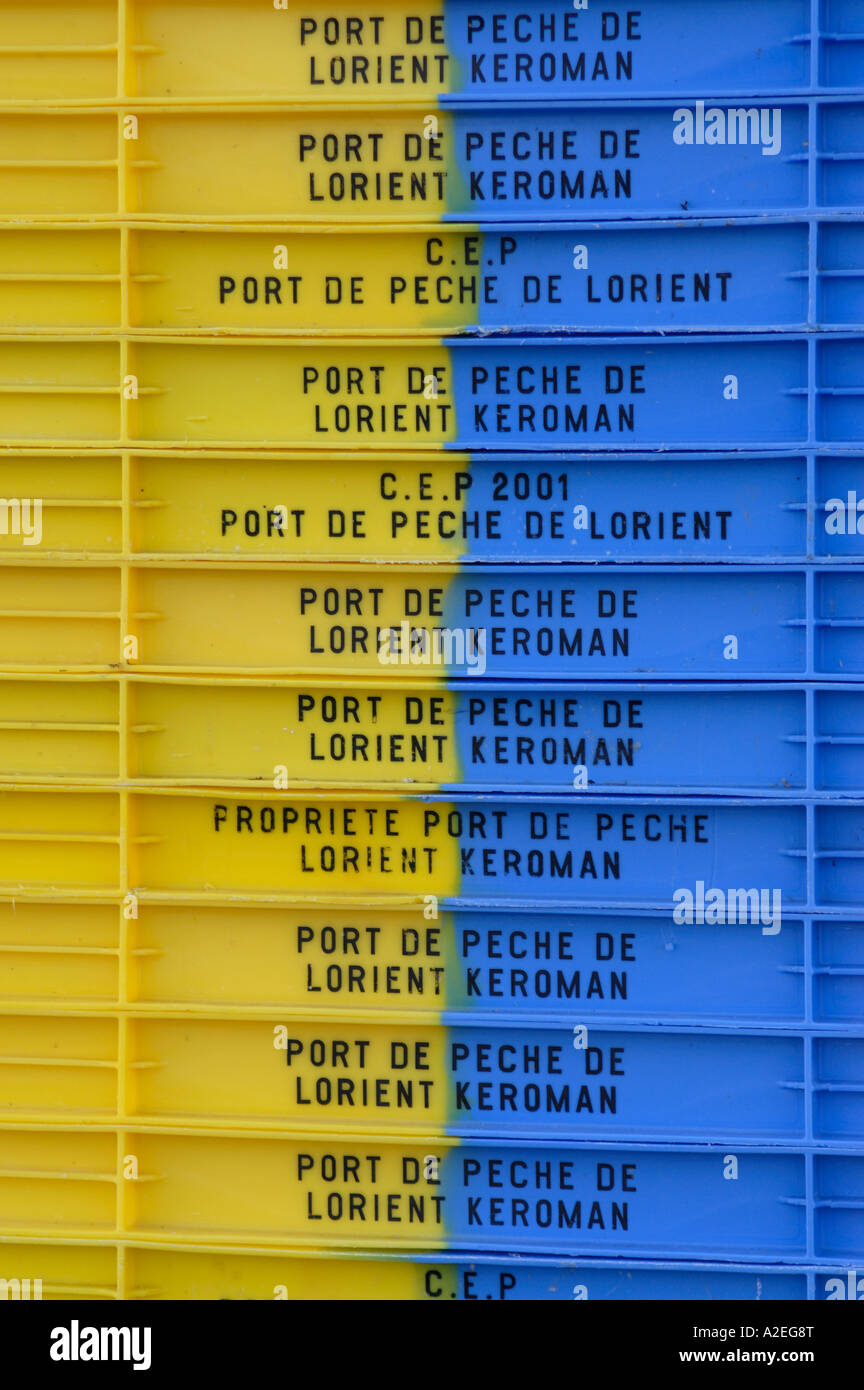 A stack of empty yellow and blue plastic fish boxes on the quay at ...