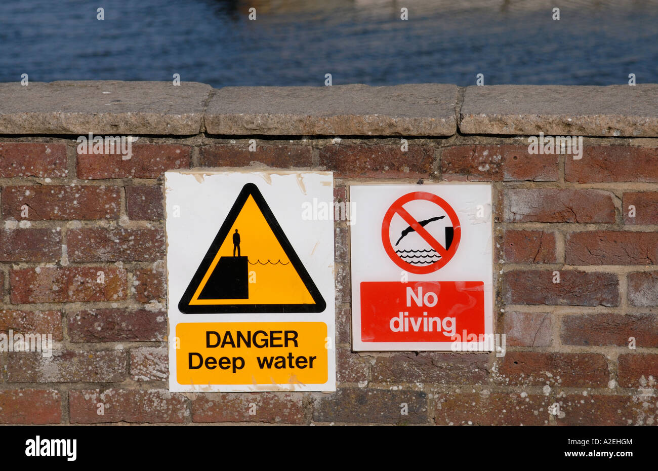 Signs saying Danger Deep Water and No Diving on a wall at the side of ...