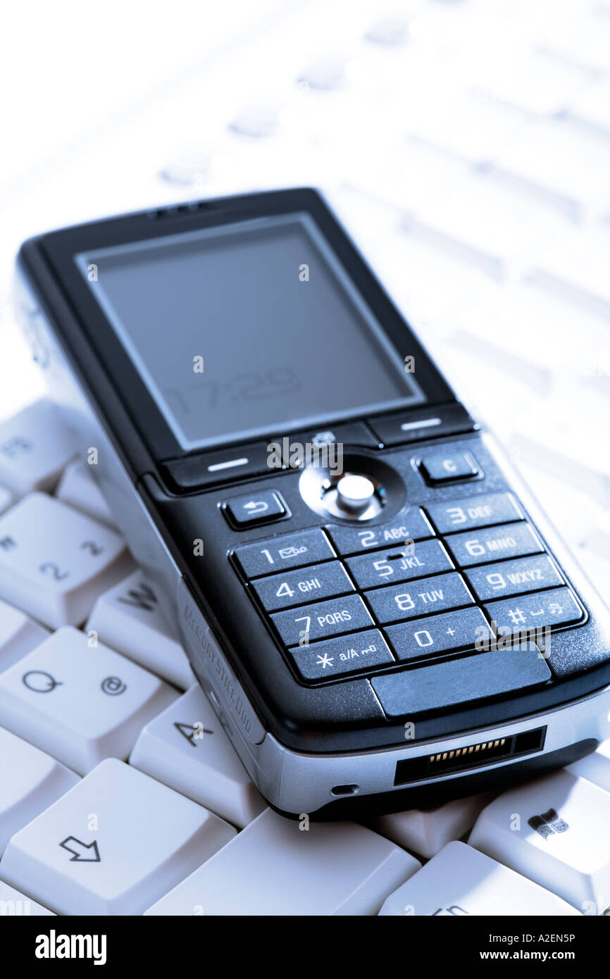 Mobile phone on keyboard, elevated view Stock Photo - Alamy