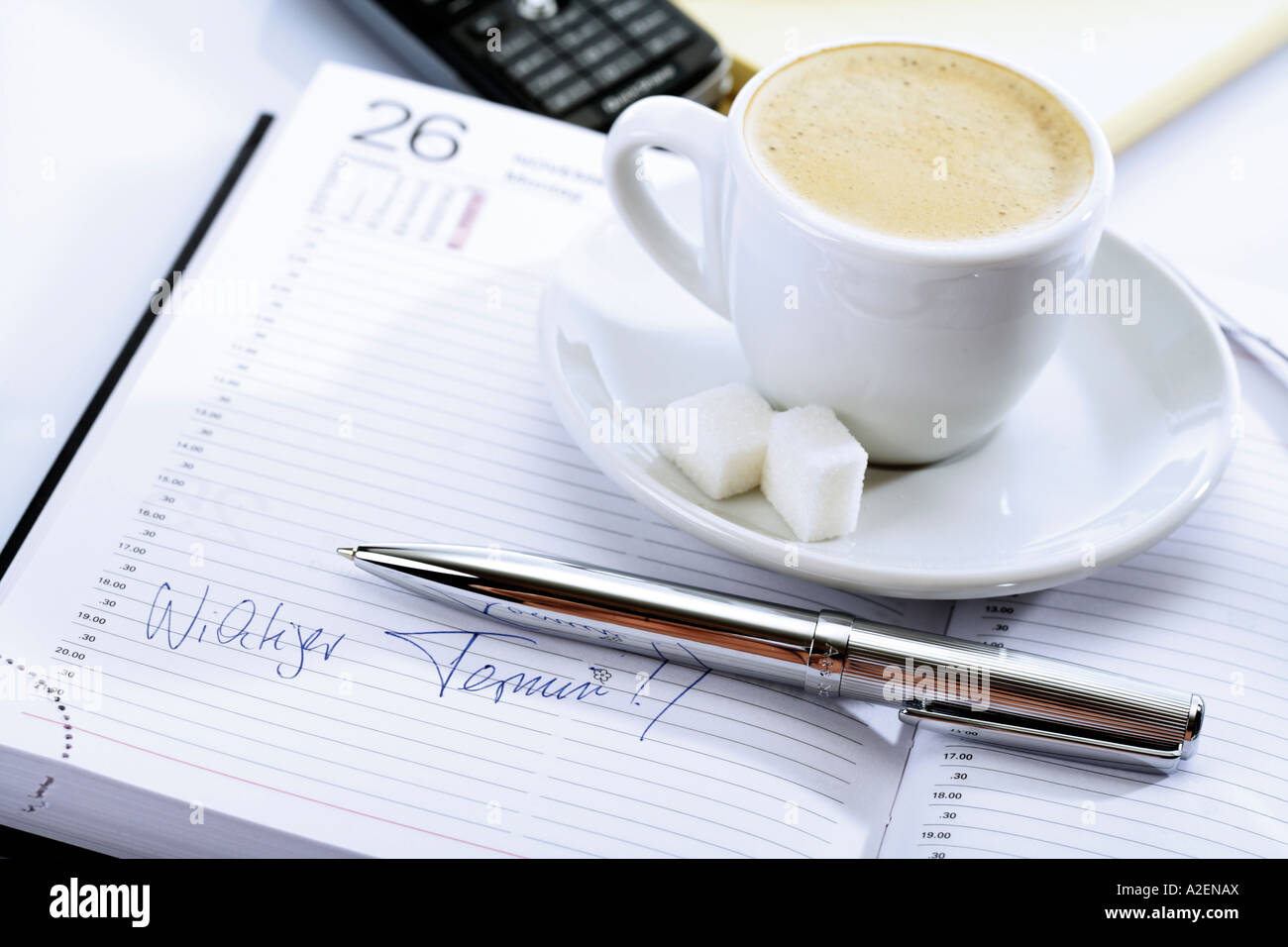 Cup of coffee on a diary, ball-point in front Stock Photo - Alamy
