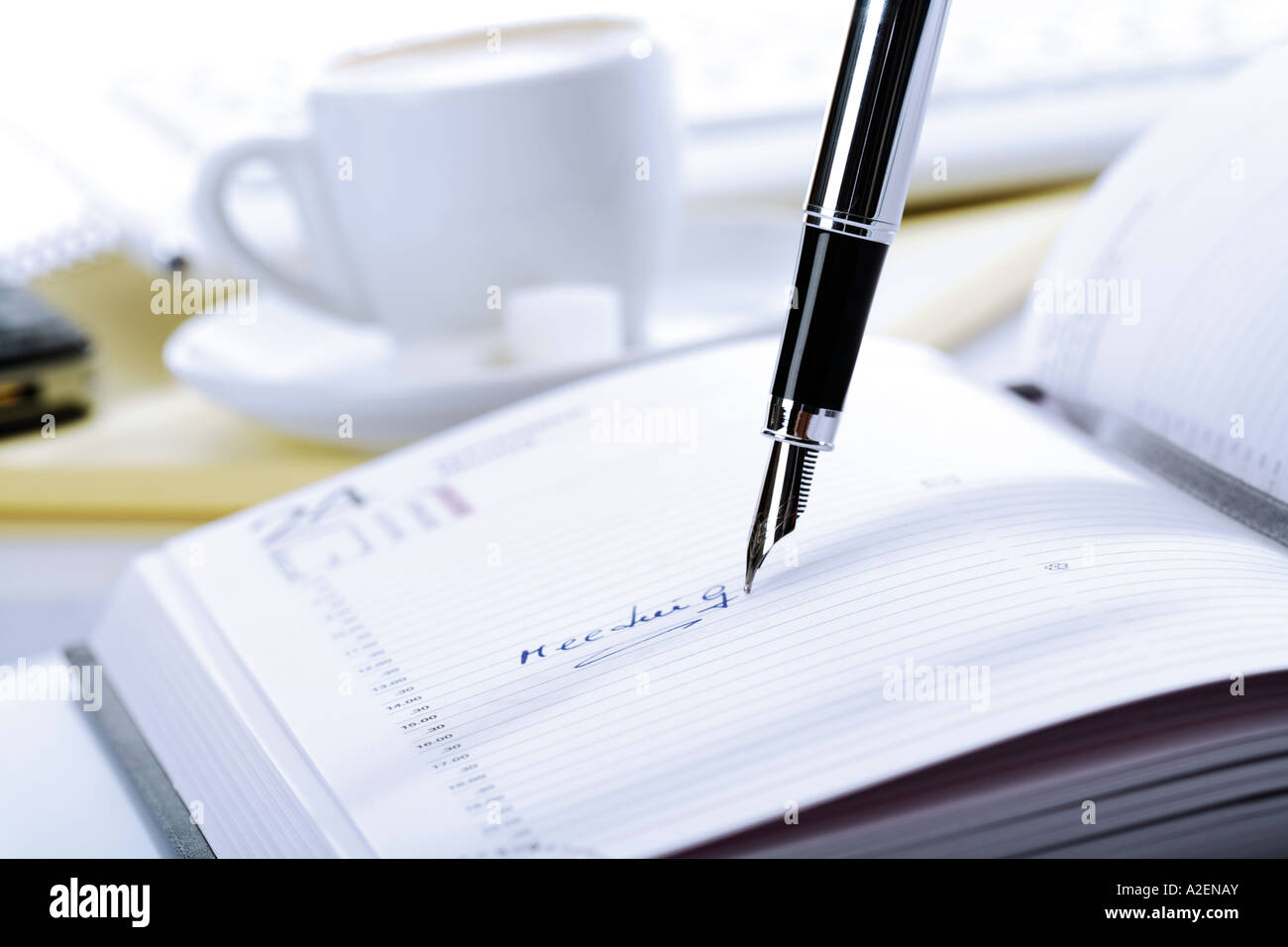 Diary and pen, cup of coffee in the background Stock Photo - Alamy