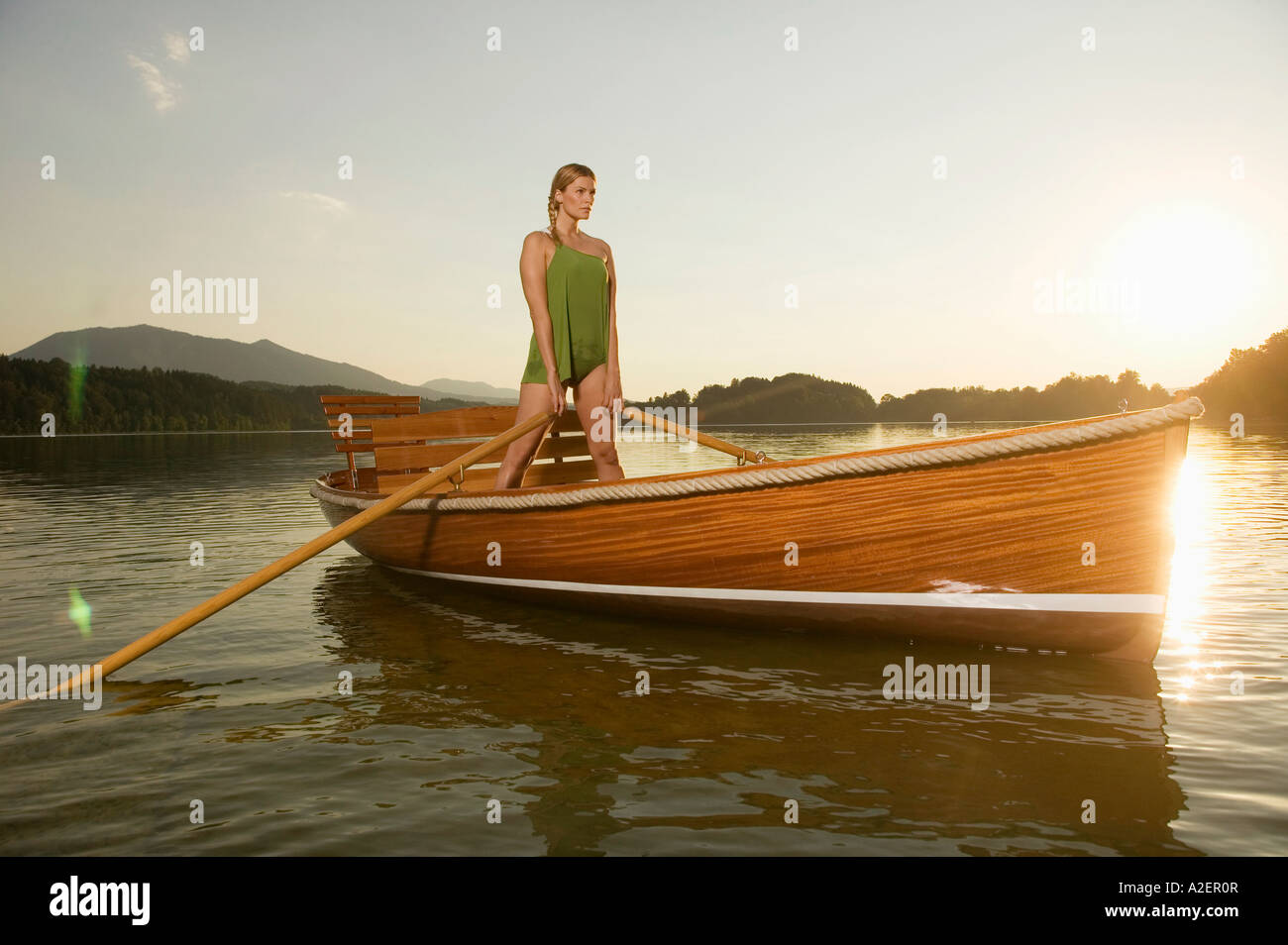 Young woman standing on rowing boat in lake Stock Photo - Alamy