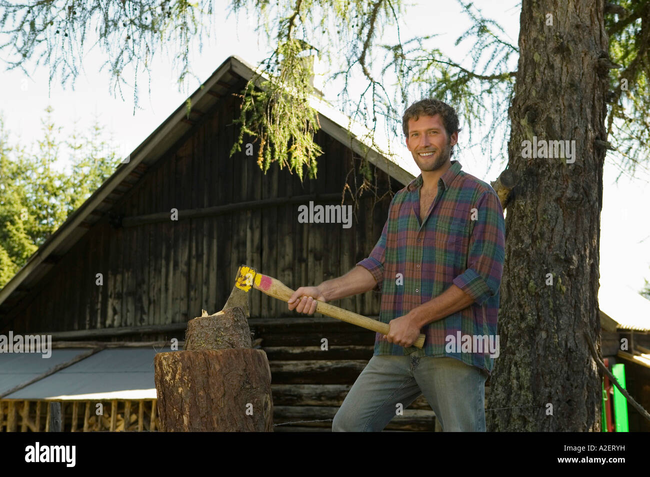 Young man chopping wood Stock Photo - Alamy