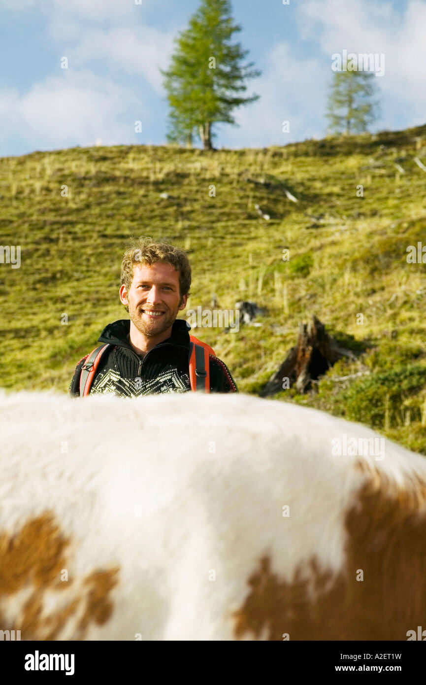 Young man standing behind cow Stock Photo - Alamy