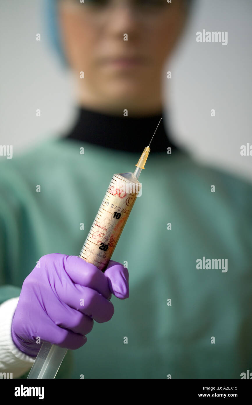 Medical NHS Cash injection 50 note in syringe held by surgeon Stock ...