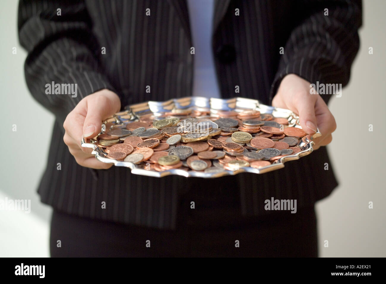 Silver tray of British coins held in 2 hands Stock Photo - Alamy