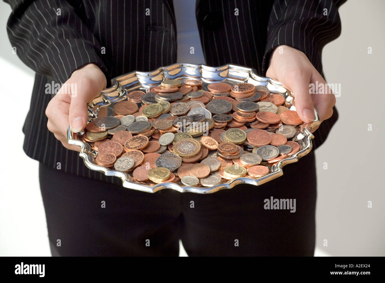 Silver tray of British coins held in 2 hands Stock Photo - Alamy