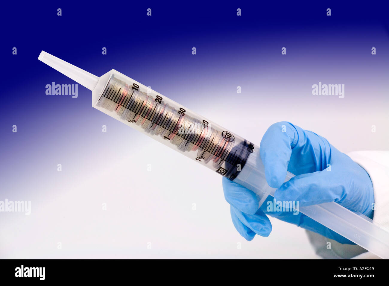 Medical Cash injection coins in syringe held by medic Stock Photo - Alamy