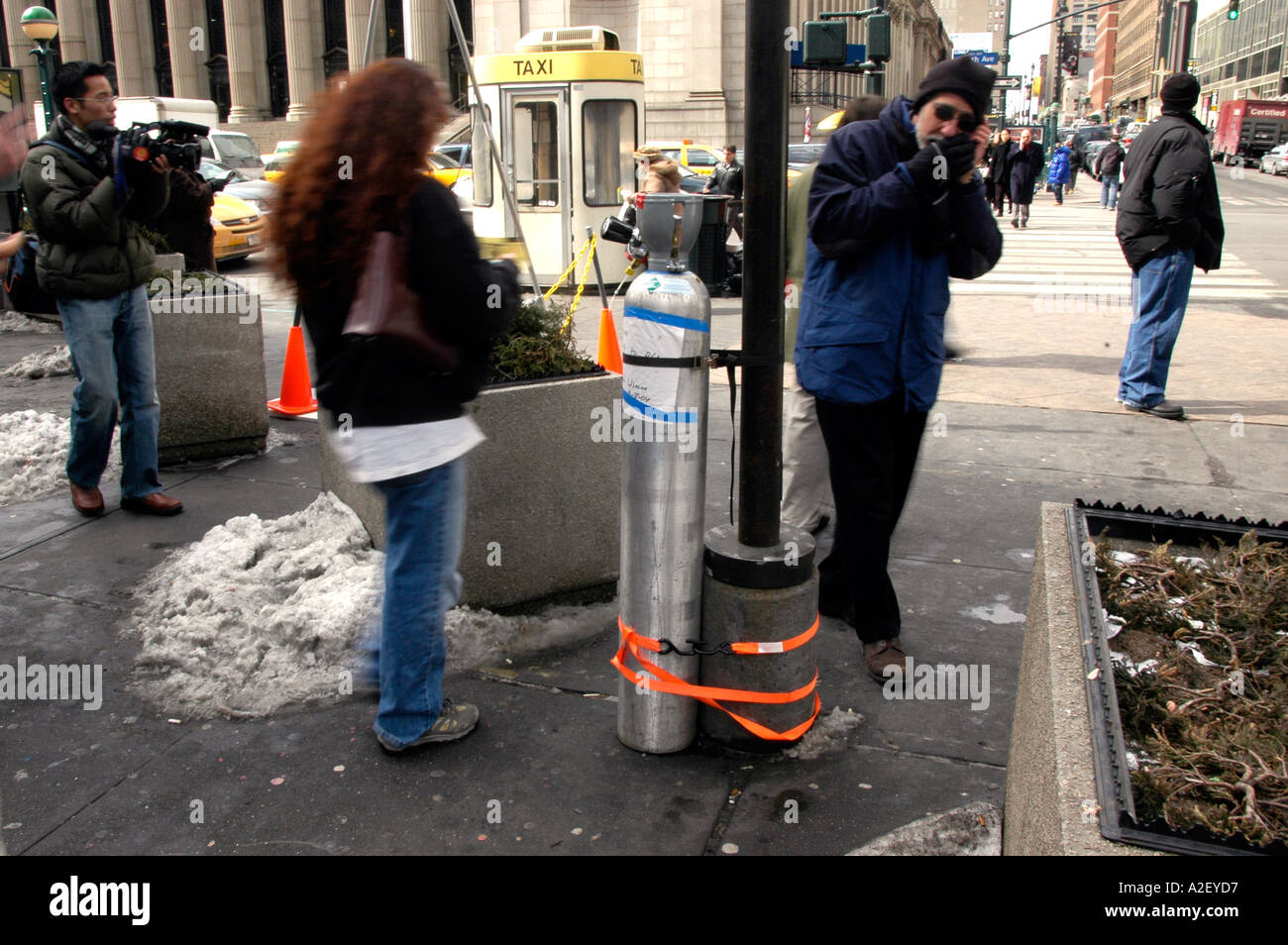 Commuters rush by a tank of Perflourocarbon PFC gas in front of ...