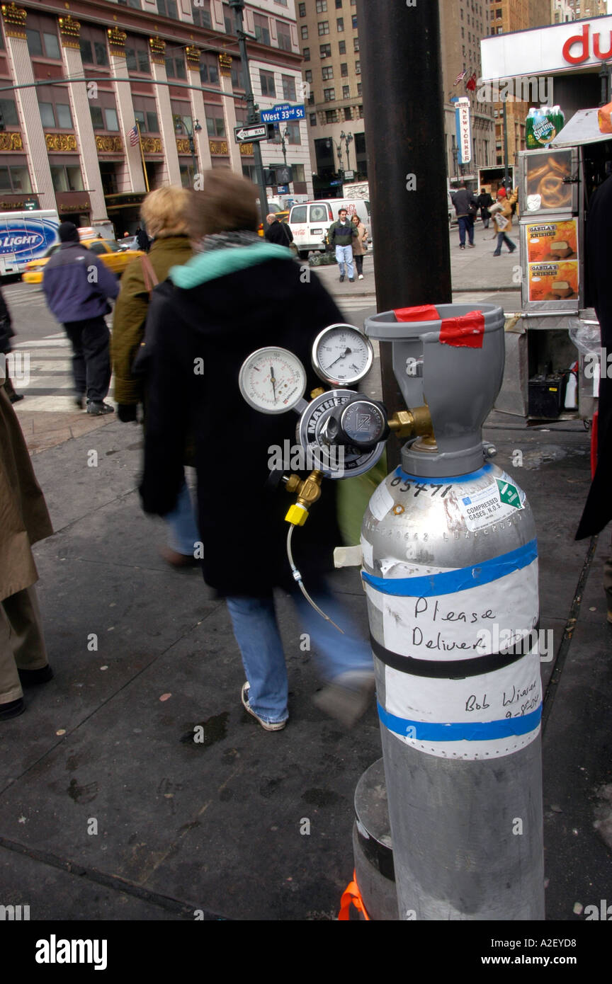Commuters rush by a tank of Perflourocarbon PFC gas in front of ...