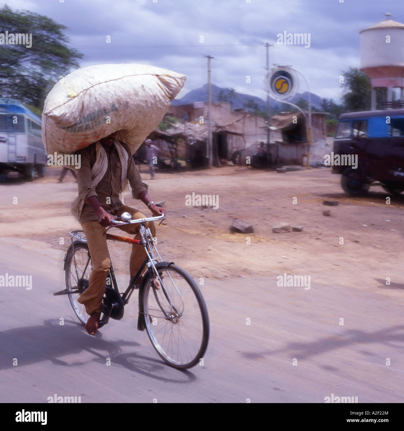 Cyclist carrying a huge sack on his head - India Stock Photo - Alamy
