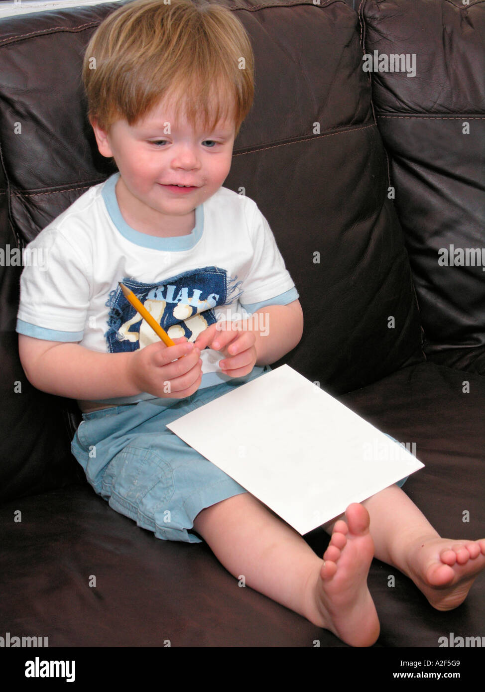 cheeky little boy with pencil and paper Stock Photo - Alamy