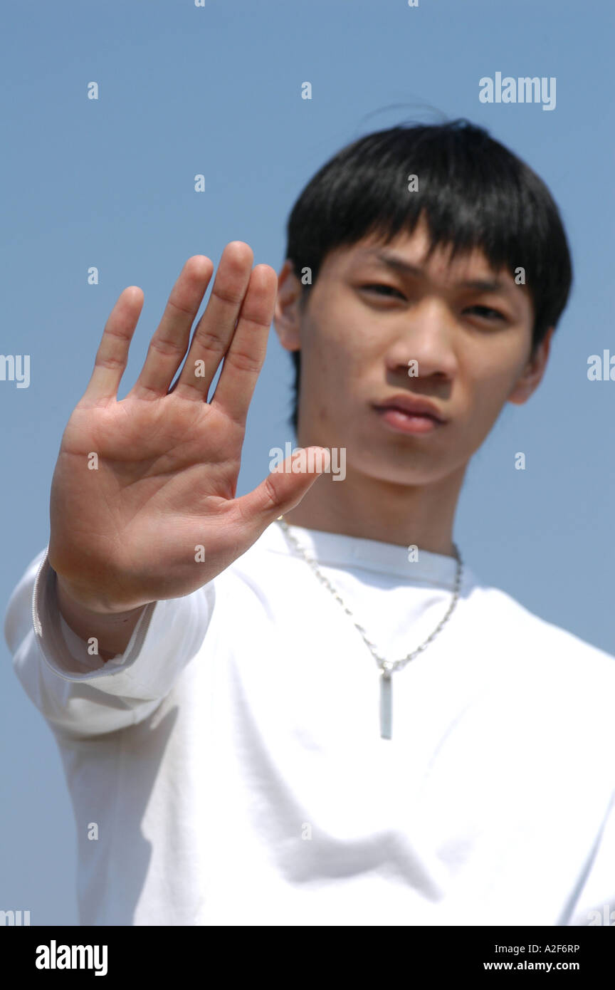 Stop do it now! Young Asian man holding hand up saying 'Stop' or 'No ...