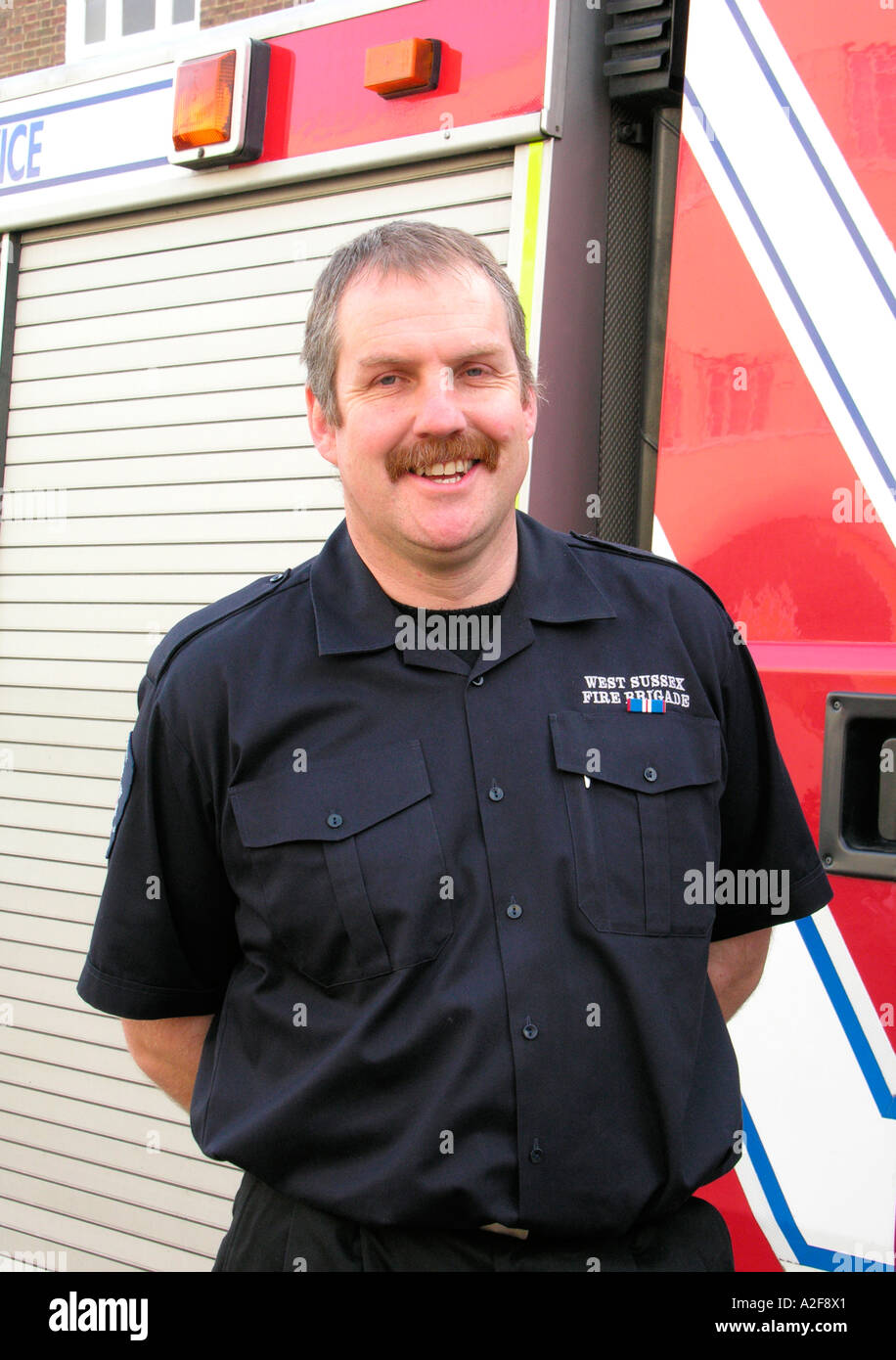 fireman standing next to West Sussex Fire and Rescue Service vehicle in ...