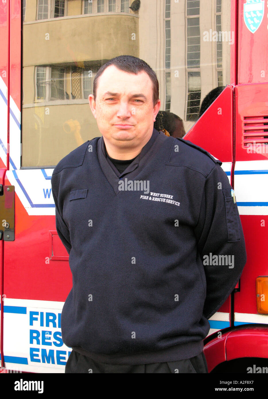 fireman standing next to West Sussex Fire and Rescue Service vehicle in ...