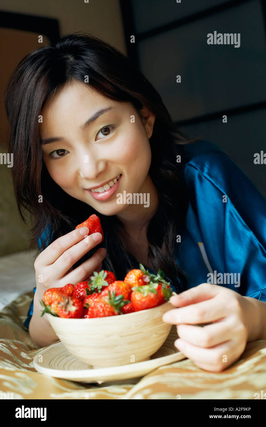 Portrait of a young woman eating a strawberry Stock Photo - Alamy