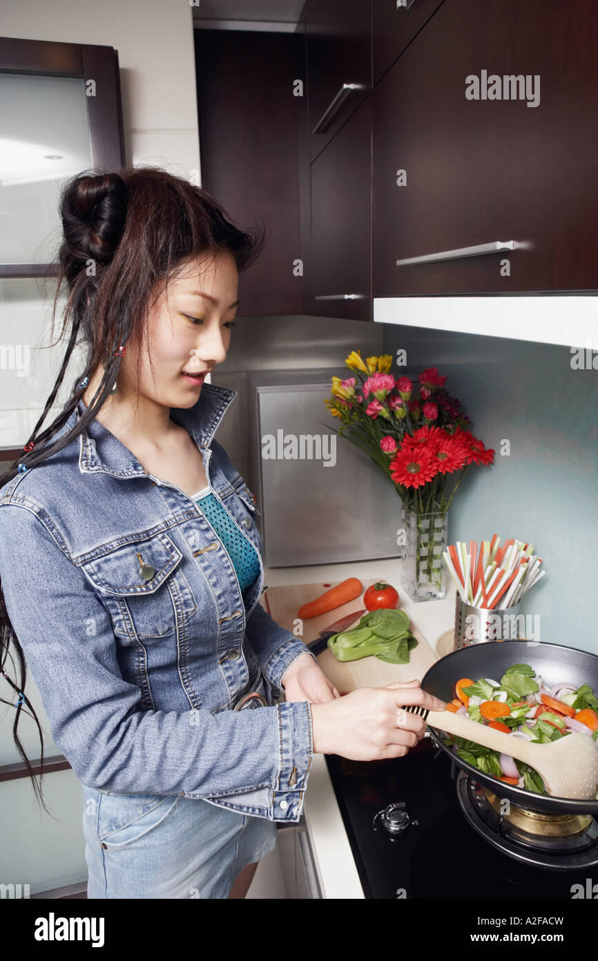 Side profile of a young woman making a dish Stock Photo - Alamy