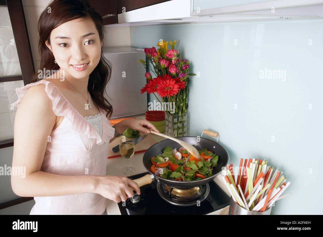 Portrait of a young woman cooking Stock Photo - Alamy
