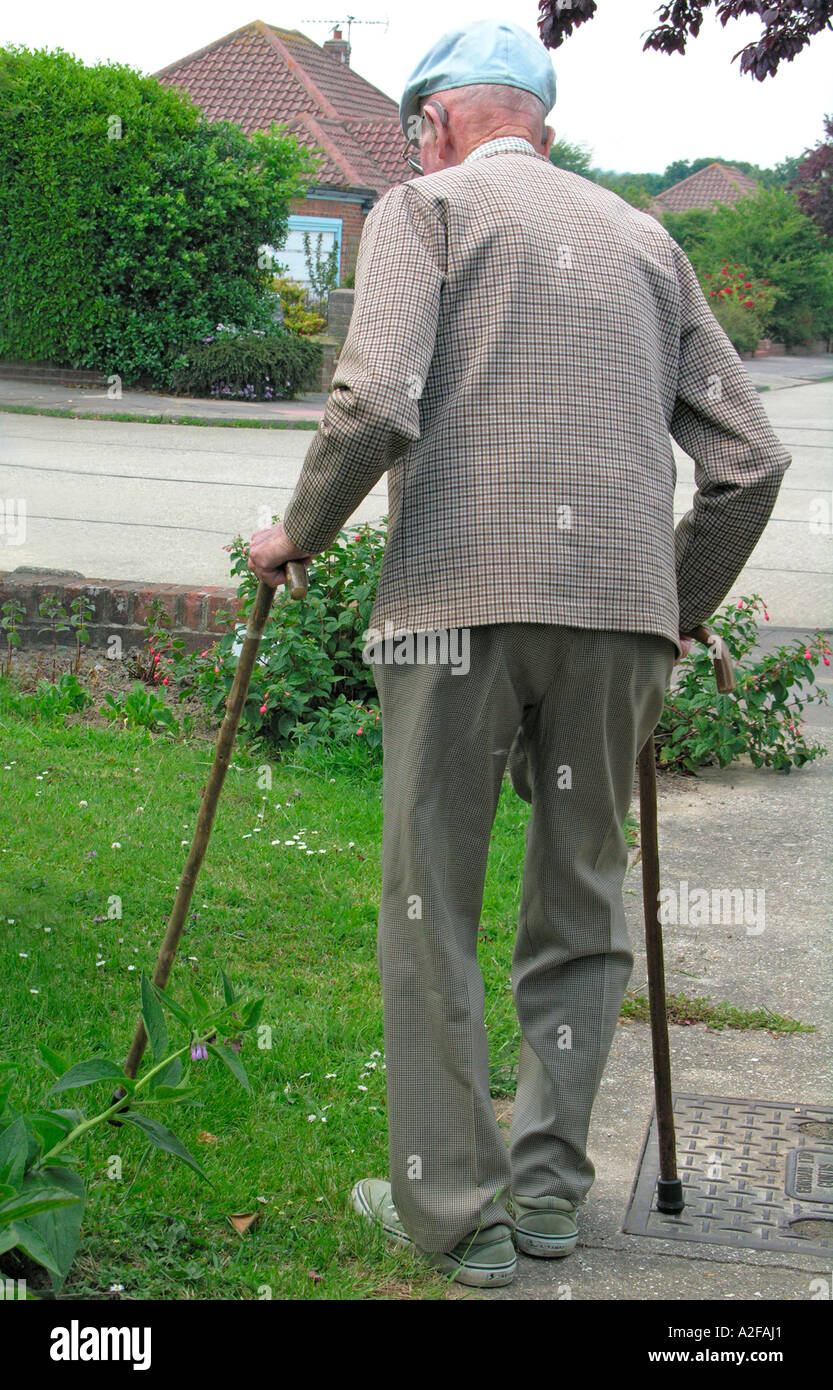 partially disabled elderly man using walking sticks struggling to get ...