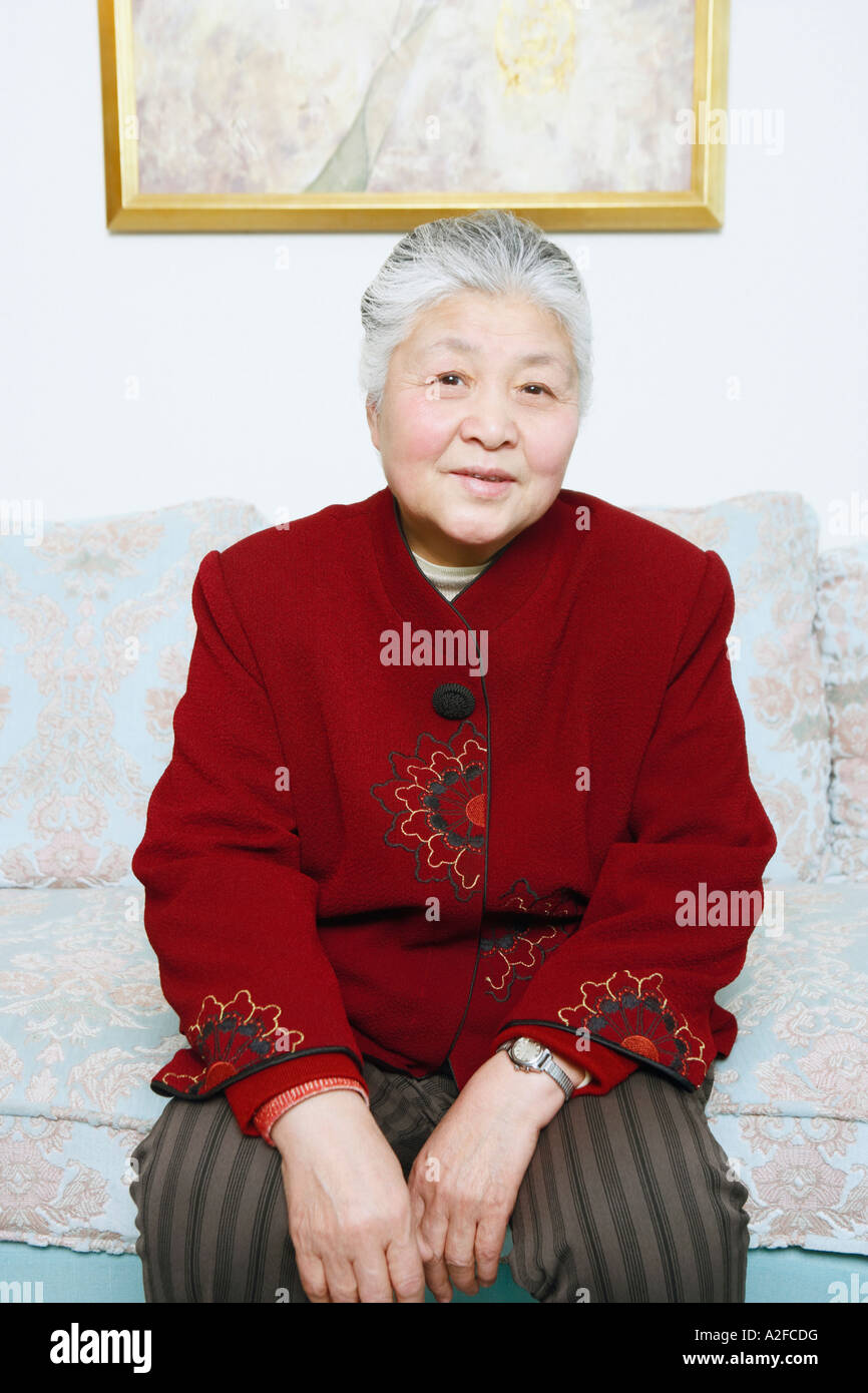 Portrait of a senior woman sitting on a couch Stock Photo - Alamy