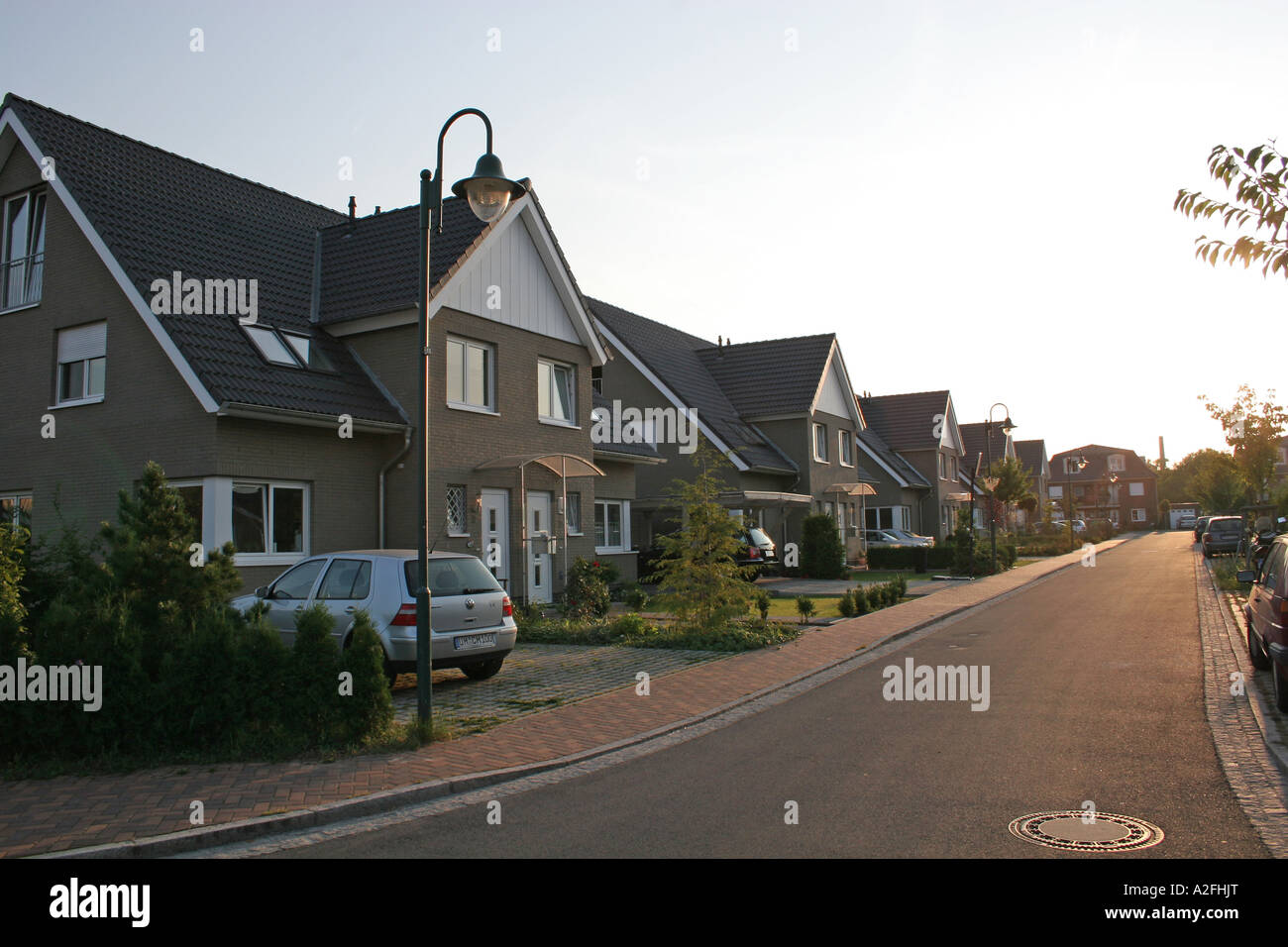 Street of a suburb housing estate in the evening light Stock Photo - Alamy